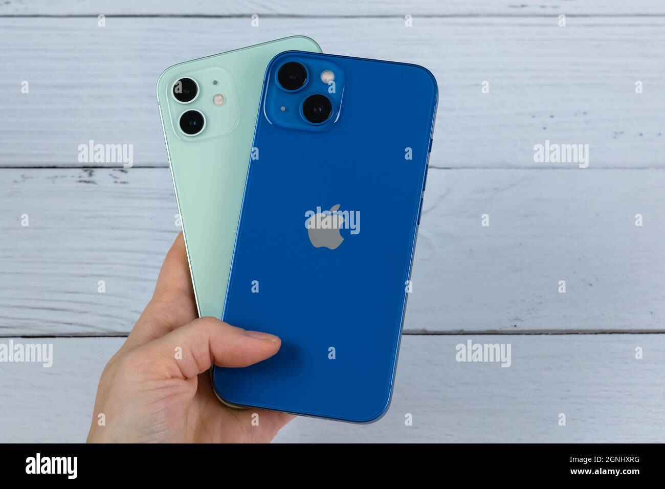 iPhone 13 in blue and iPhone 12 in green Stock Photo - Alamy