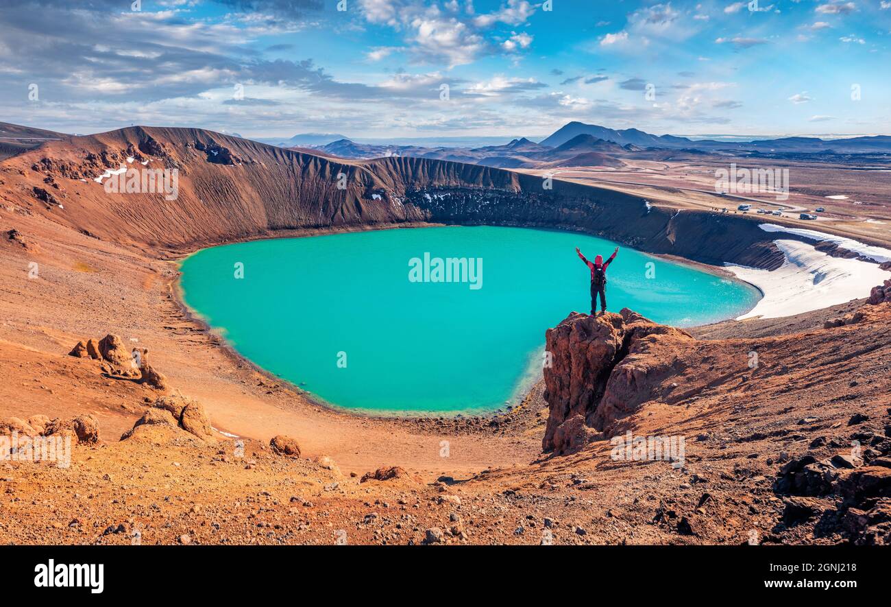Tourist standing on the edge of cliff on Krafla Viti Crater lake with ...