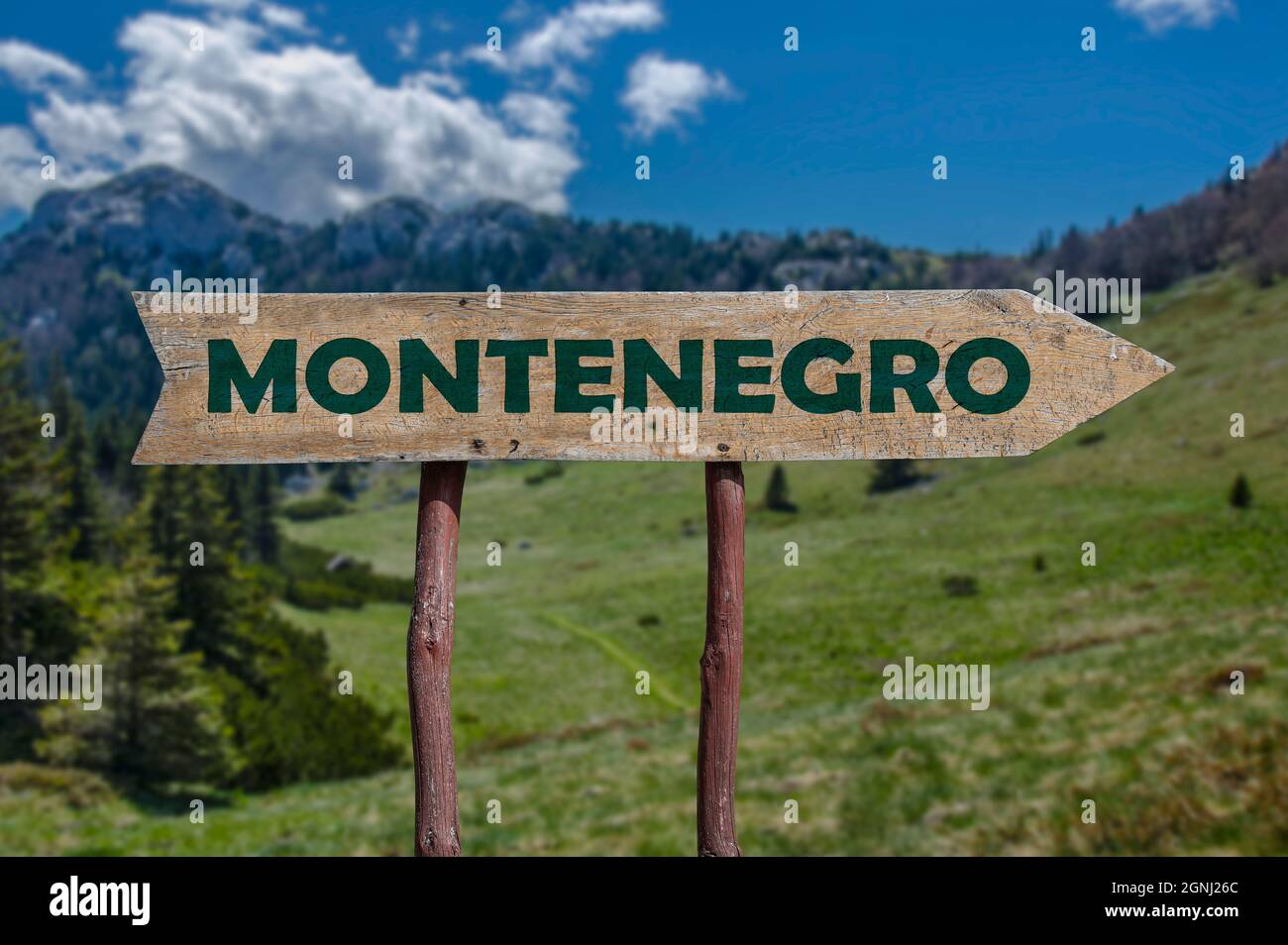 Montenegro wooden arrow road sign against mountain valley background ...