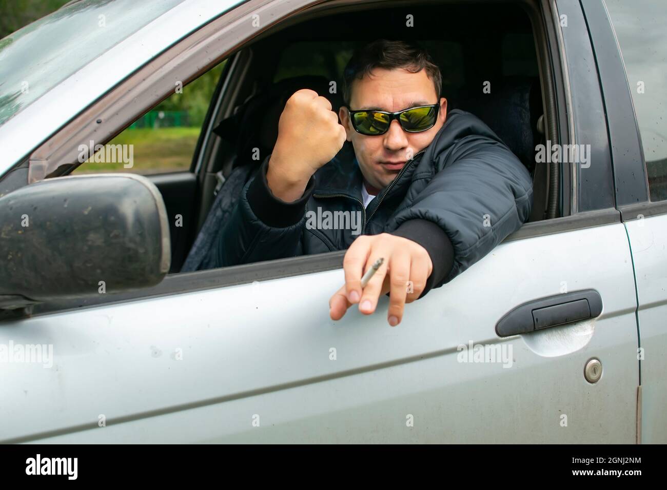 the fist of an angry, angry man, a driver who is sitting at the wheel ...