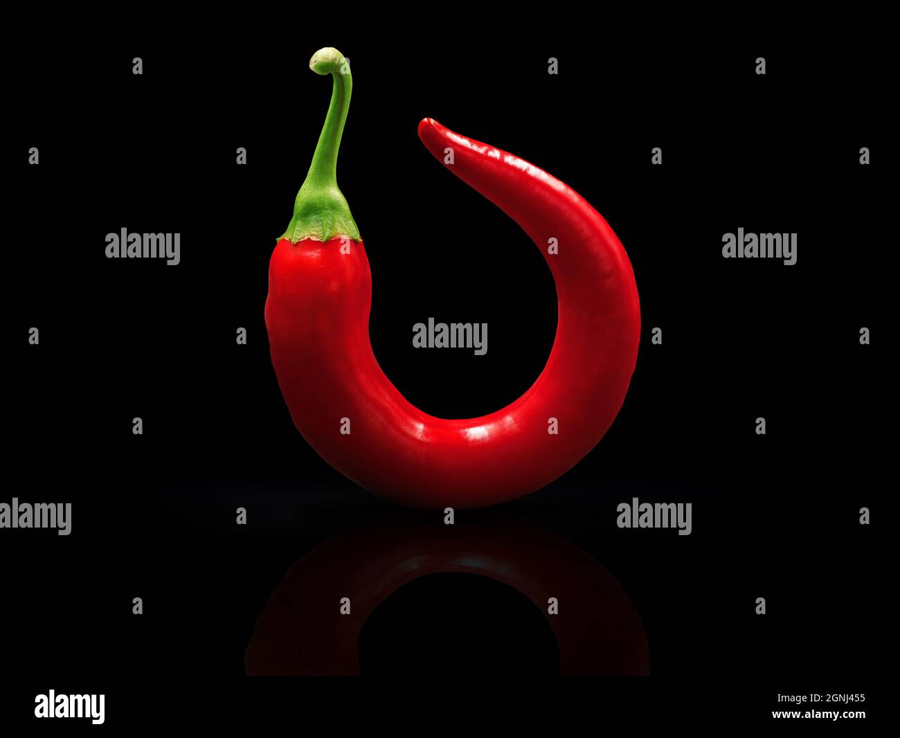 round curved red chili pepper isolated on black background Stock Photo ...