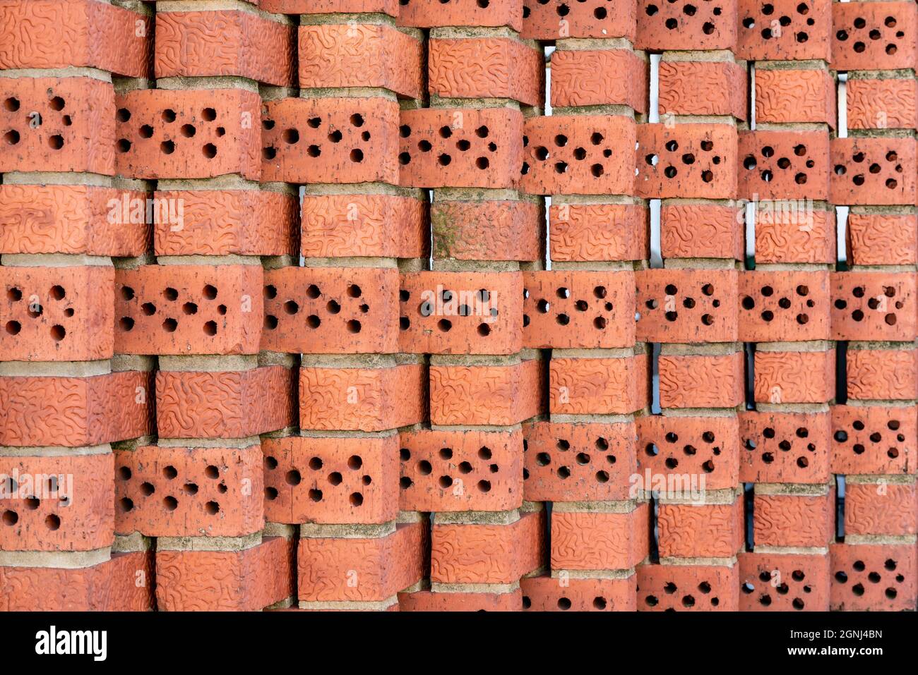 A wall with red bricks with holes for air circulation Stock Photo - Alamy