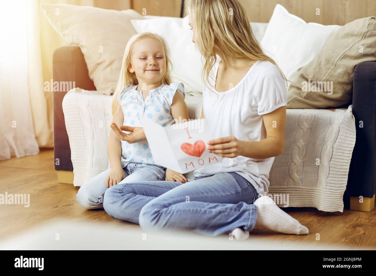 Happy mother day in sunny flat. Child daughter congratulates mom and ...