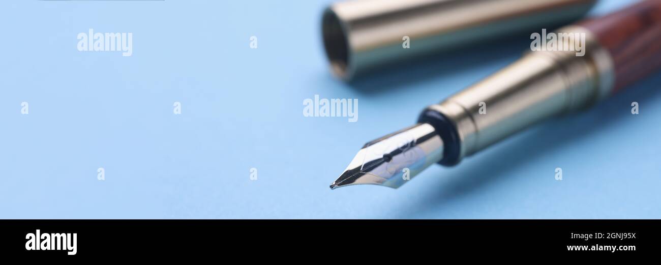 Open fountain pen on light blue background Stock Photo - Alamy