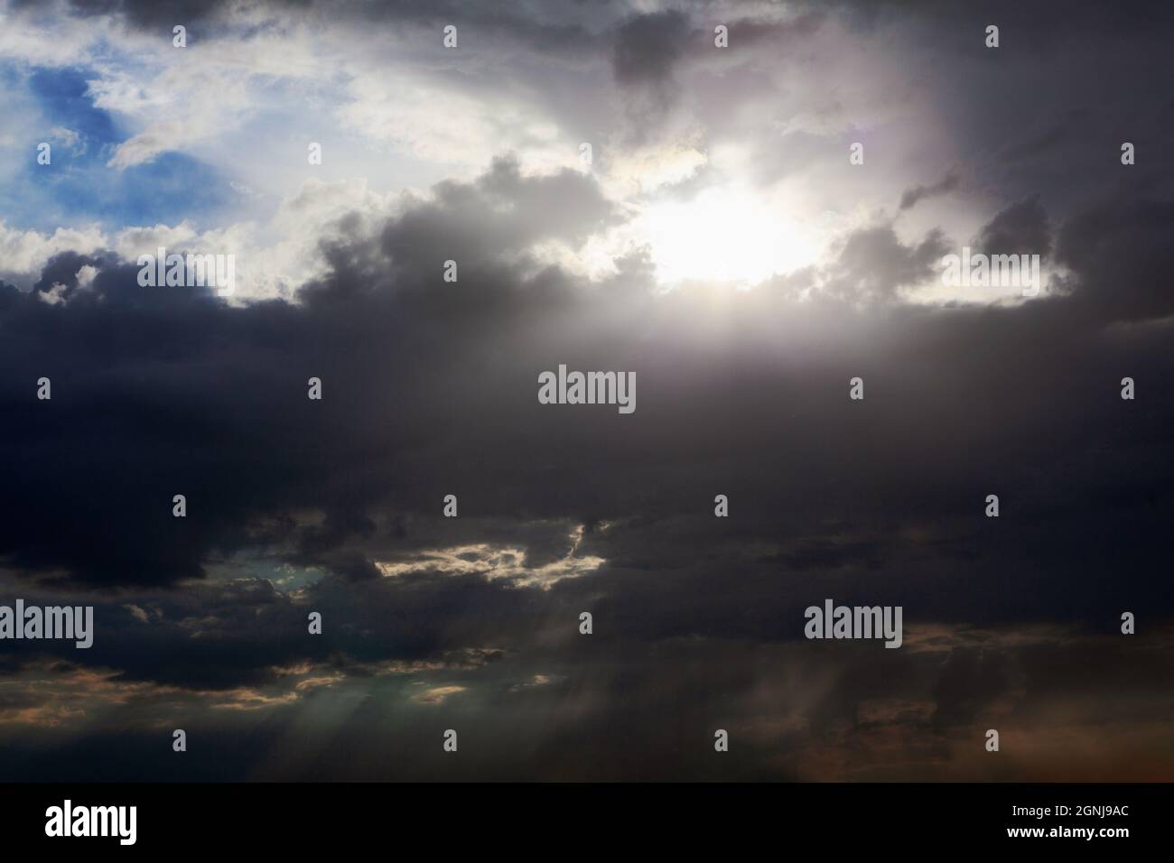 Sun breaking through clouds . Dark clouds with sun rays . Sky before ...