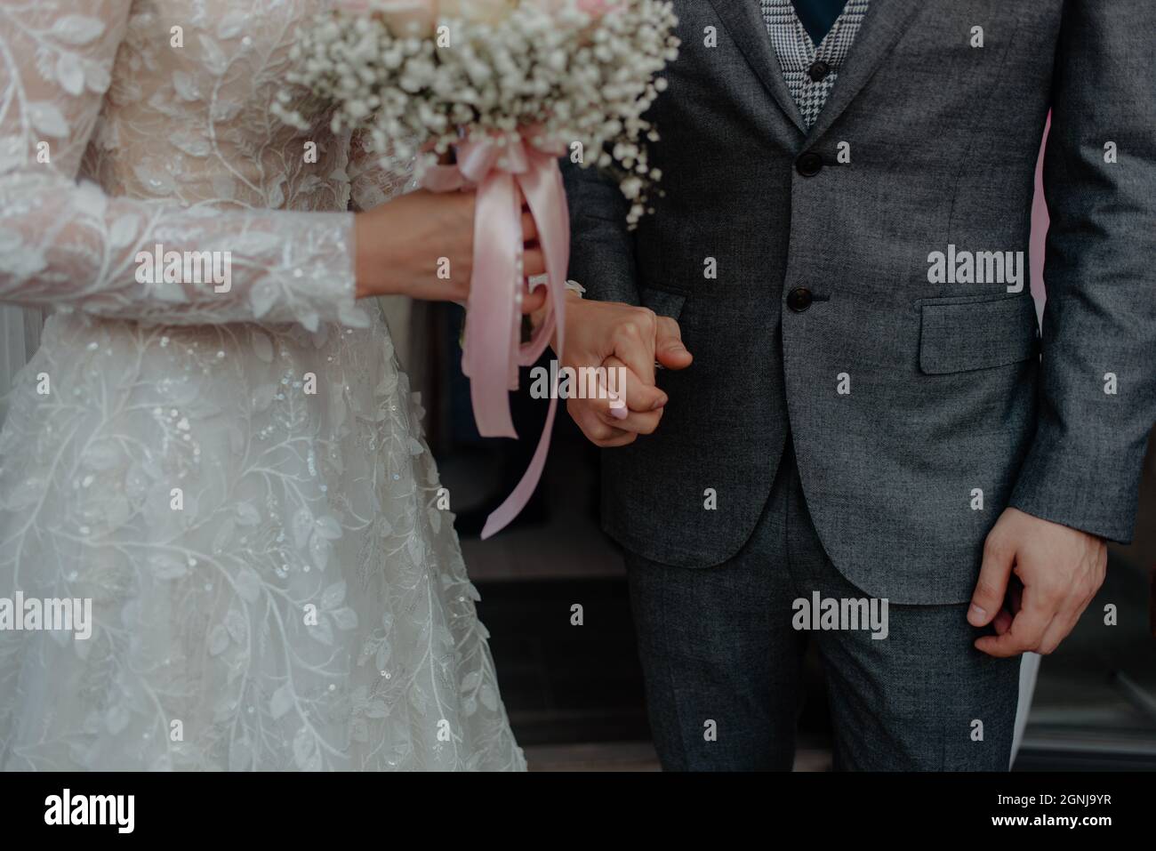A marrying couple holding each other's hands Stock Photo - Alamy