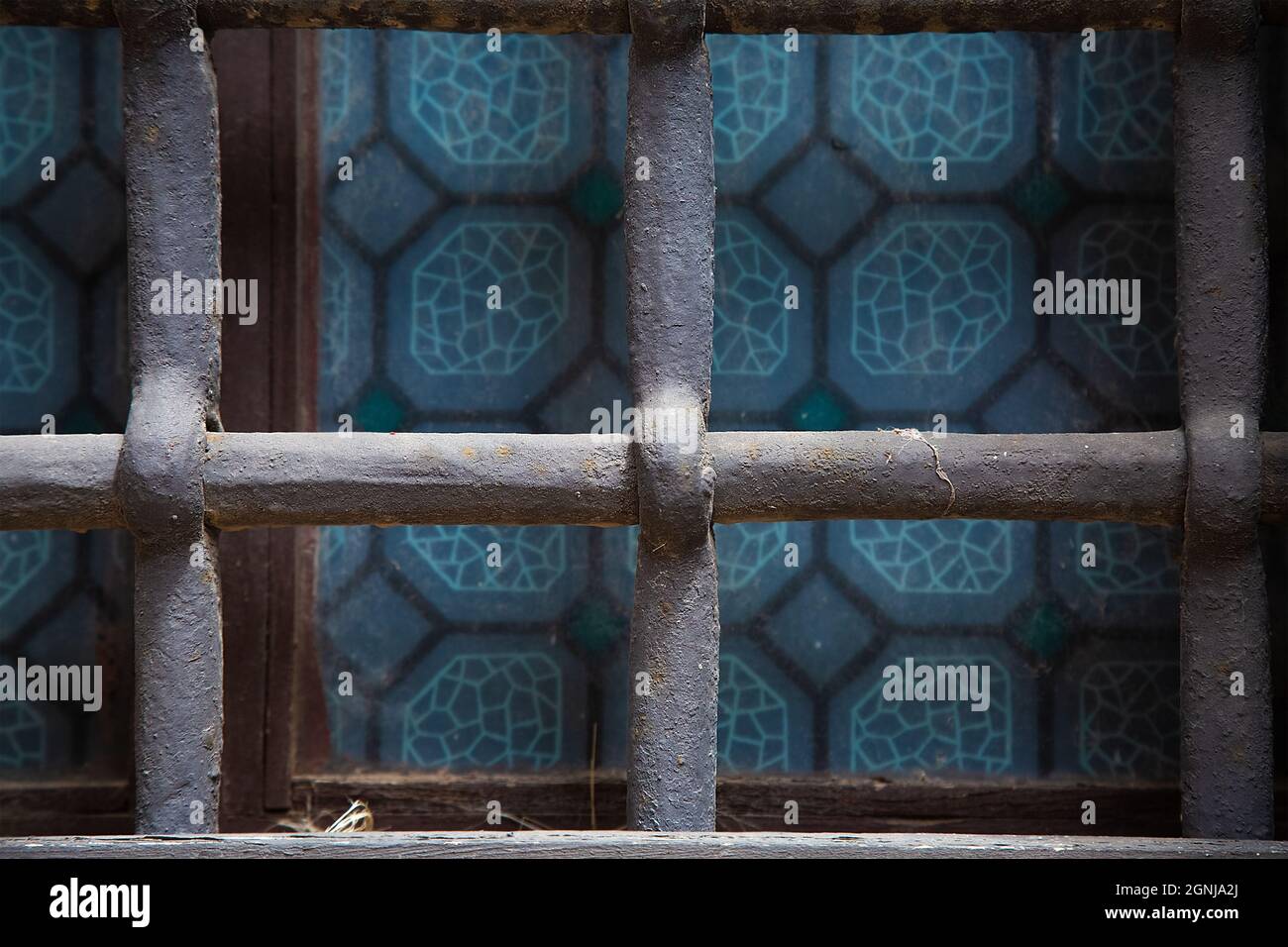 Cast Iron grid on window with blue stained glass. Background and ...
