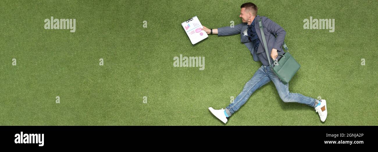 Young businessman happily running with work papers Stock Photo - Alamy