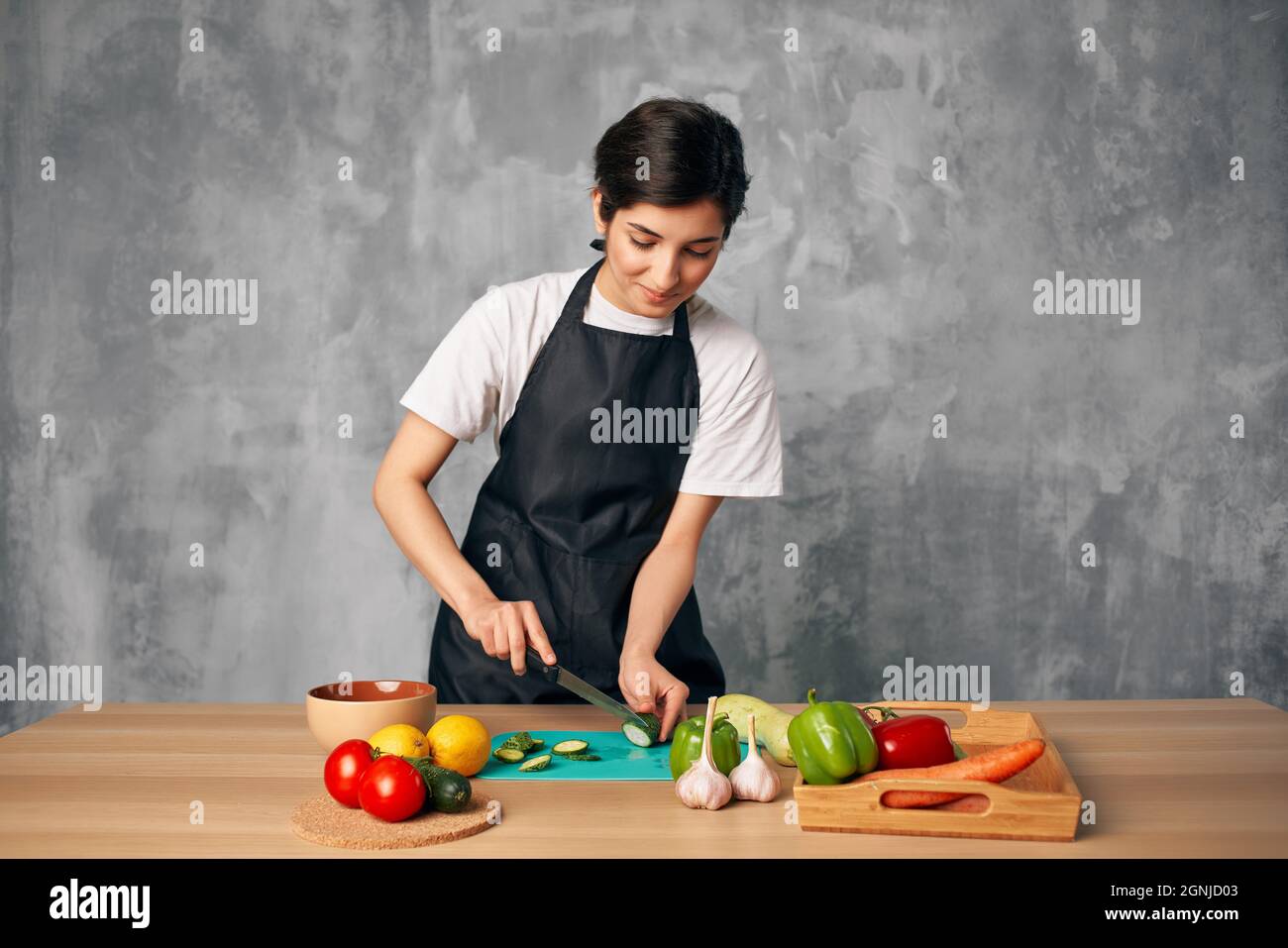 Woman in black apron Cooking healthy eating salad Stock Photo - Alamy