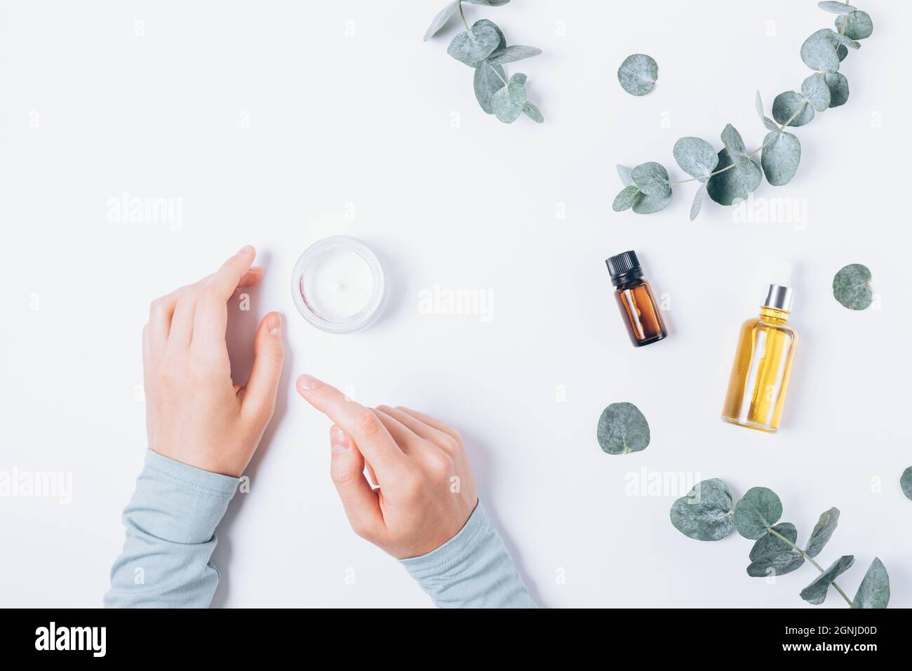 Female hands apply cosmetic cream next to natural beauty products and ...