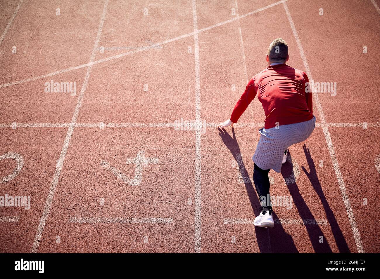 image from above of a man on start line, ready to start running on ...