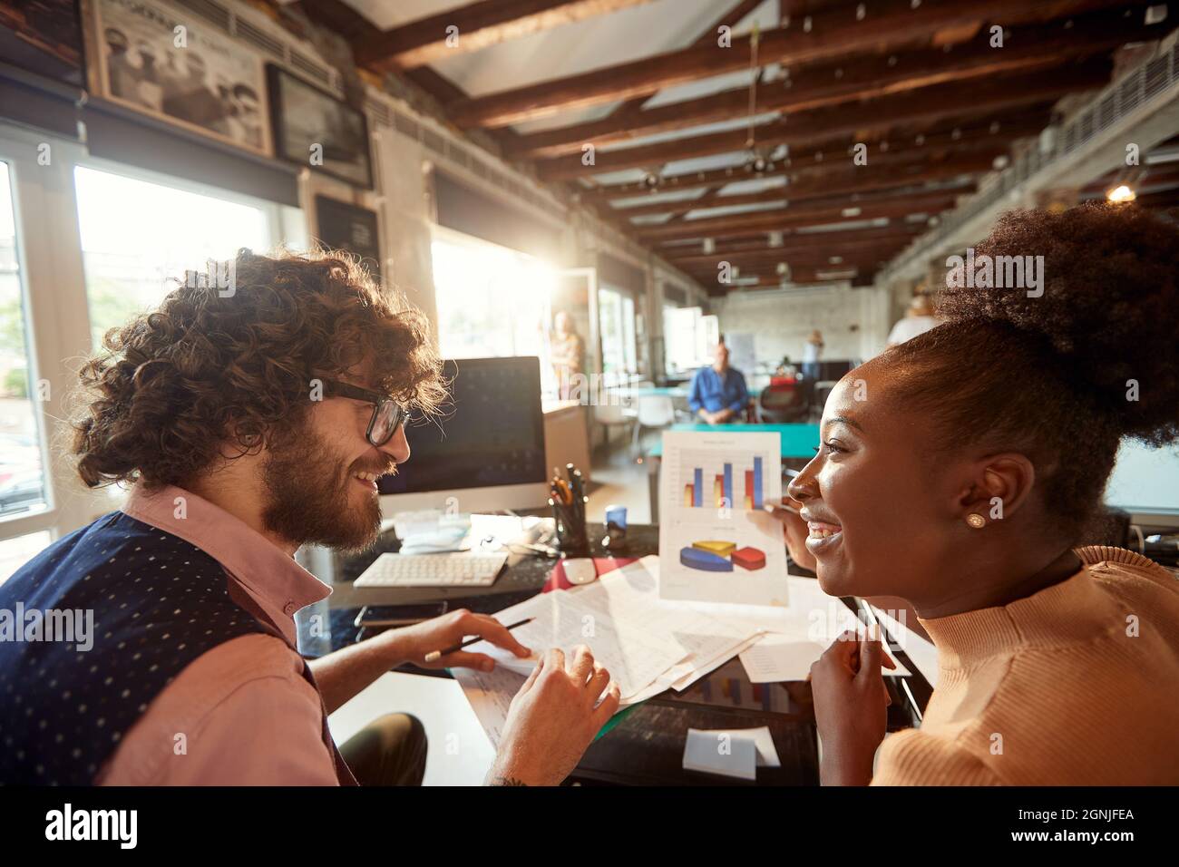 Young colleagues in a pleasant atmosphere in the office are talking ...