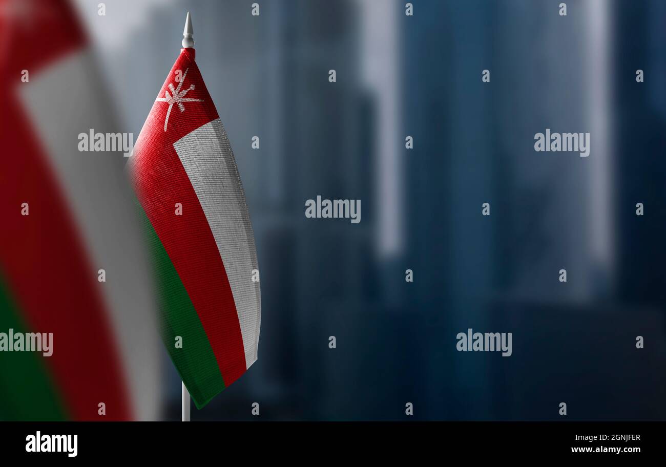 Small flags of Oman on a blurry background of the city Stock Photo - Alamy
