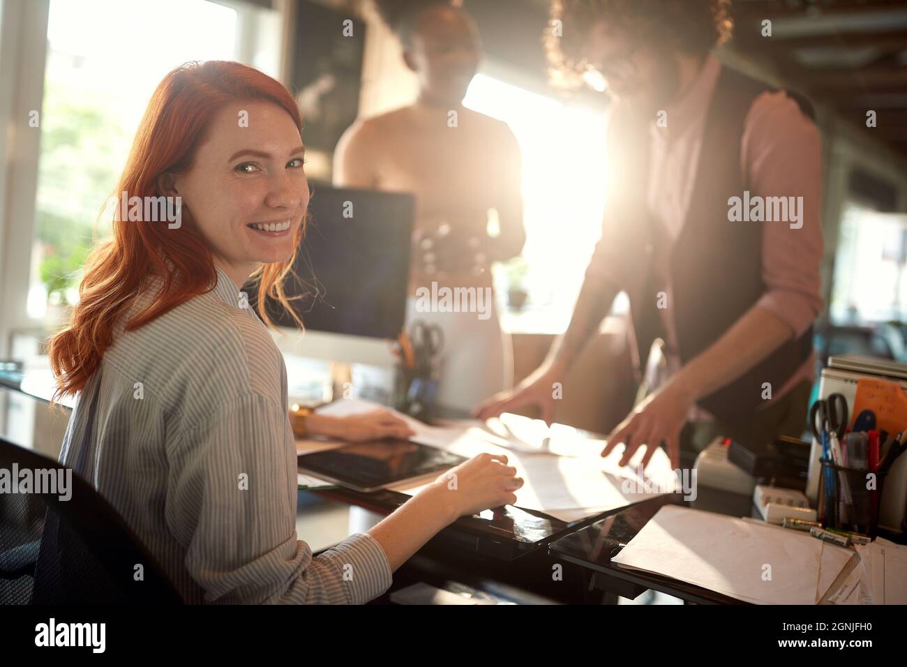 A new young female employee is posing for a photo at her new job in a ...