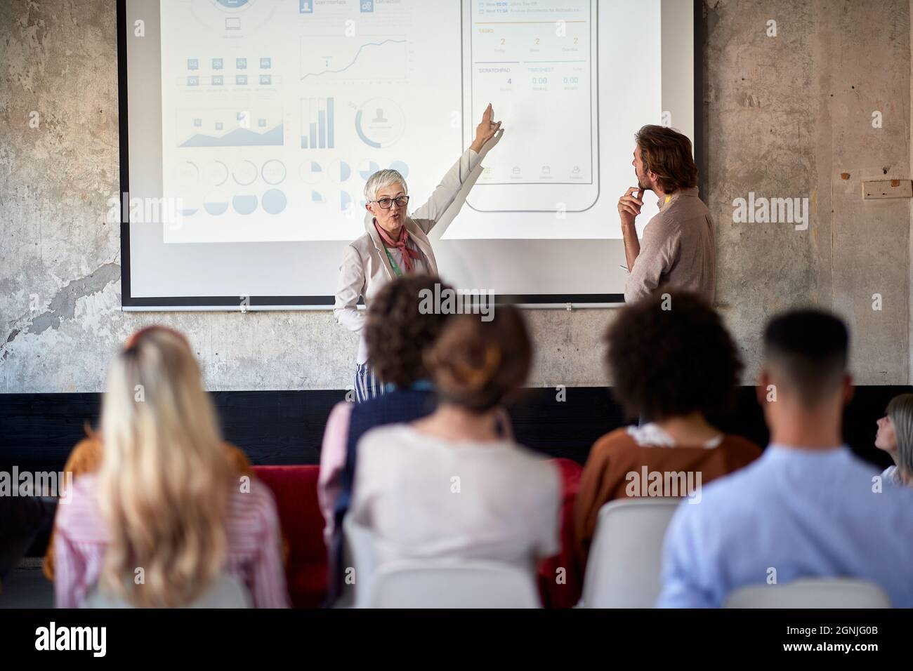 Elderly woman is holding a lecture to employees in a pleasant ...