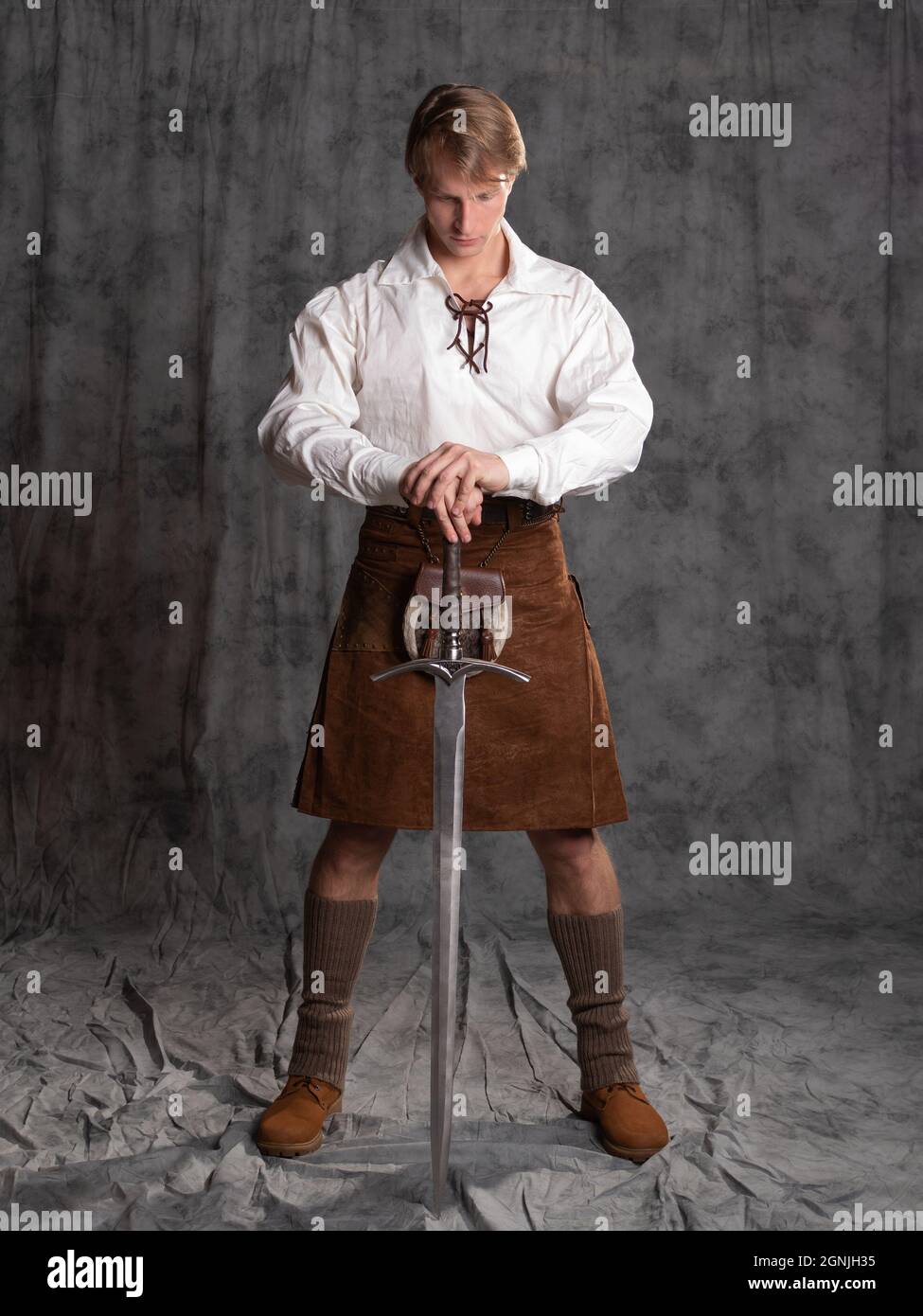 A young man in a leather kilt and a white lace-up blouse. A Scottish ...