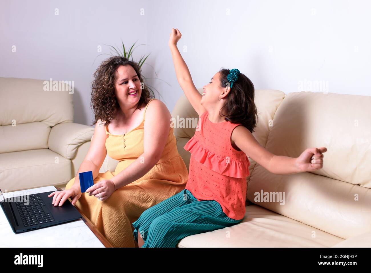 Happy girl raising her arms because her mother has bought her what she ...