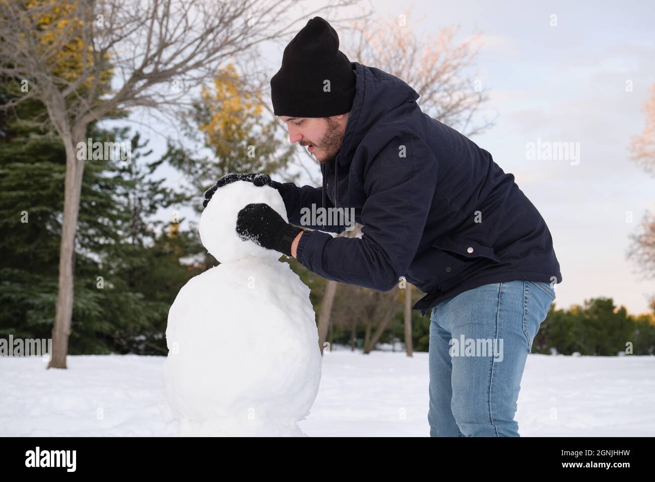 Young caucasian man making a snowman Stock Photo - Alamy