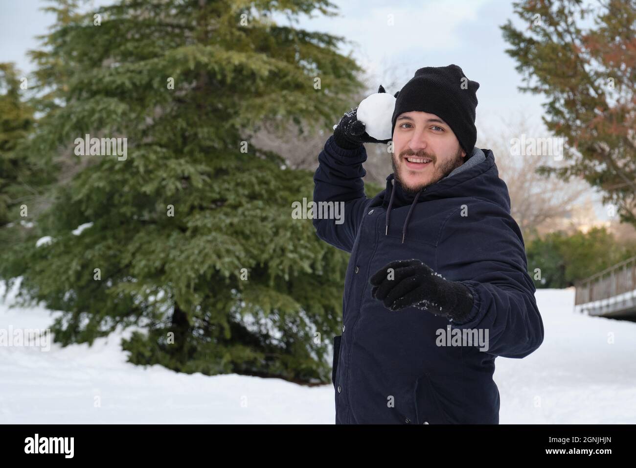 Young caucasian man ready to throw a snowball in a park Stock Photo - Alamy