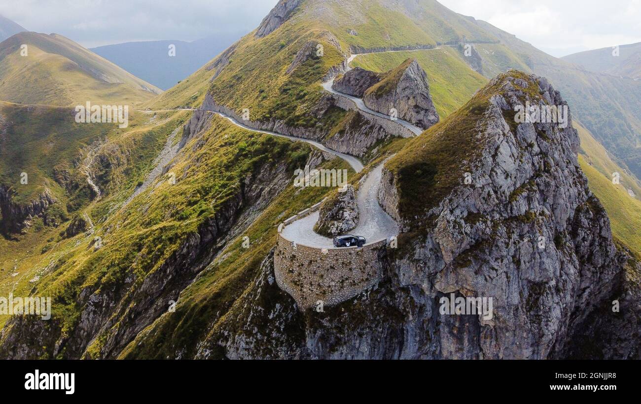 An aerial view of a narrow winding road at the top of a rocky mountain ...