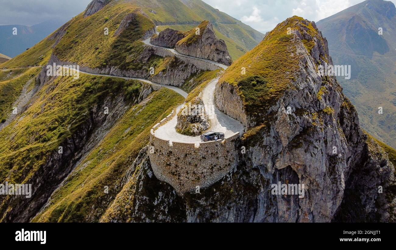 An aerial view of a narrow winding road at the top of a rocky mountain ...
