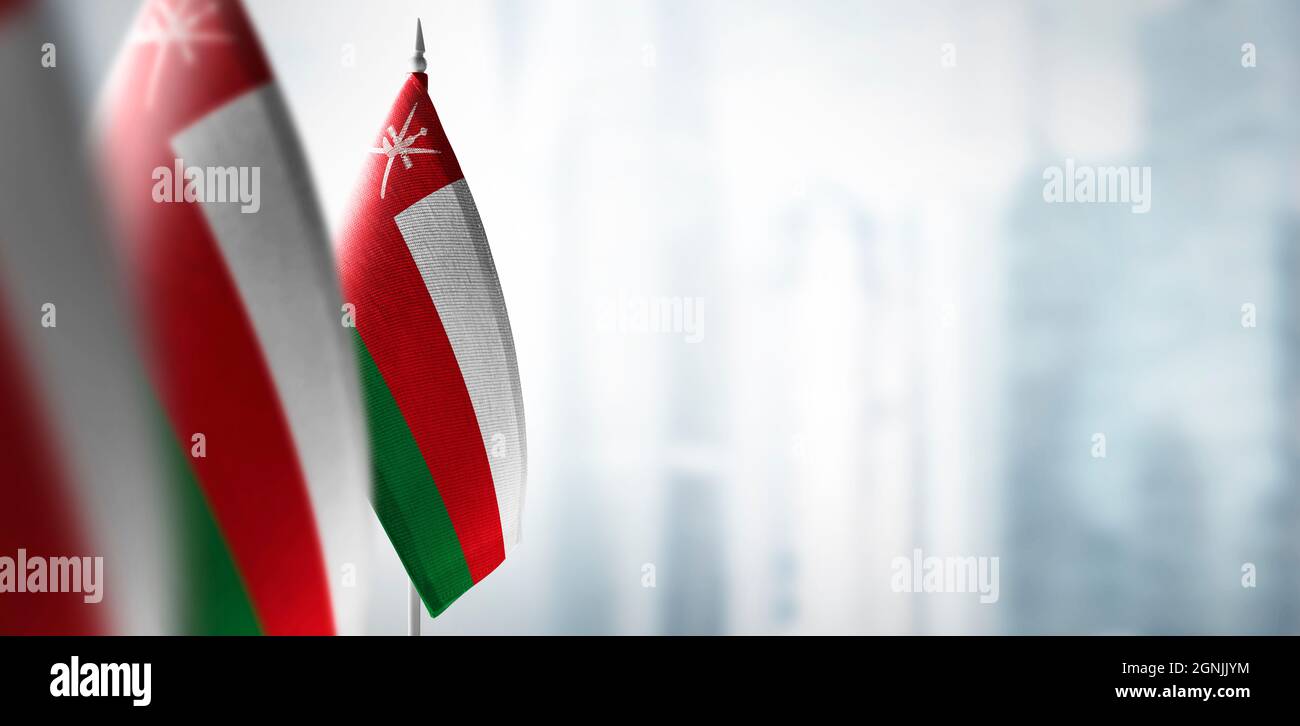 Small flags of Oman on a blurry background of the city Stock Photo - Alamy