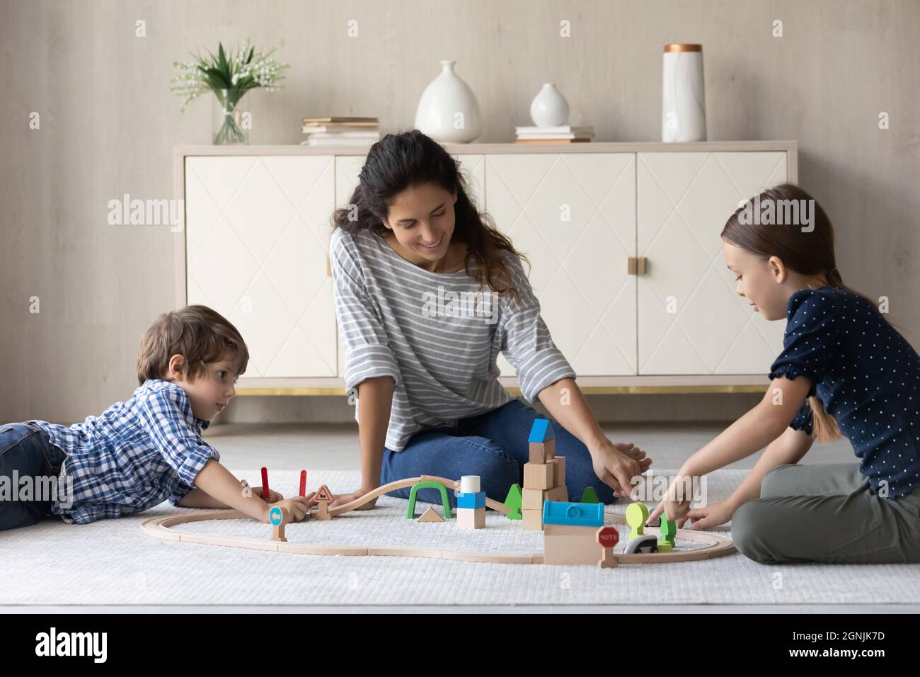 Happy young mum playing toys with small kids Stock Photo - Alamy