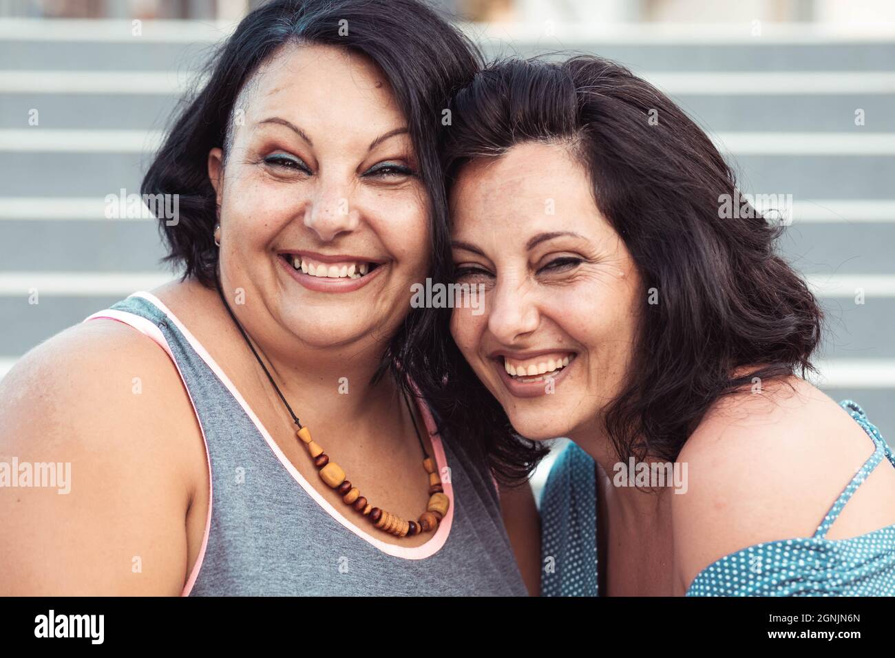 Portrait of two adult brunette twin sisters. Different styles Stock ...