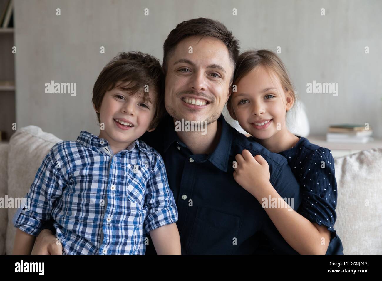 Portrait of affectionate young father and little children siblings ...