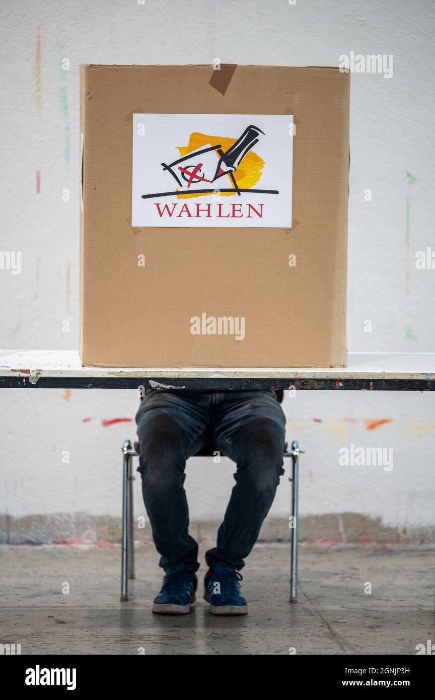 Trier, Germany. 26th Sep, 2021. An eligible voter sits in the polling ...