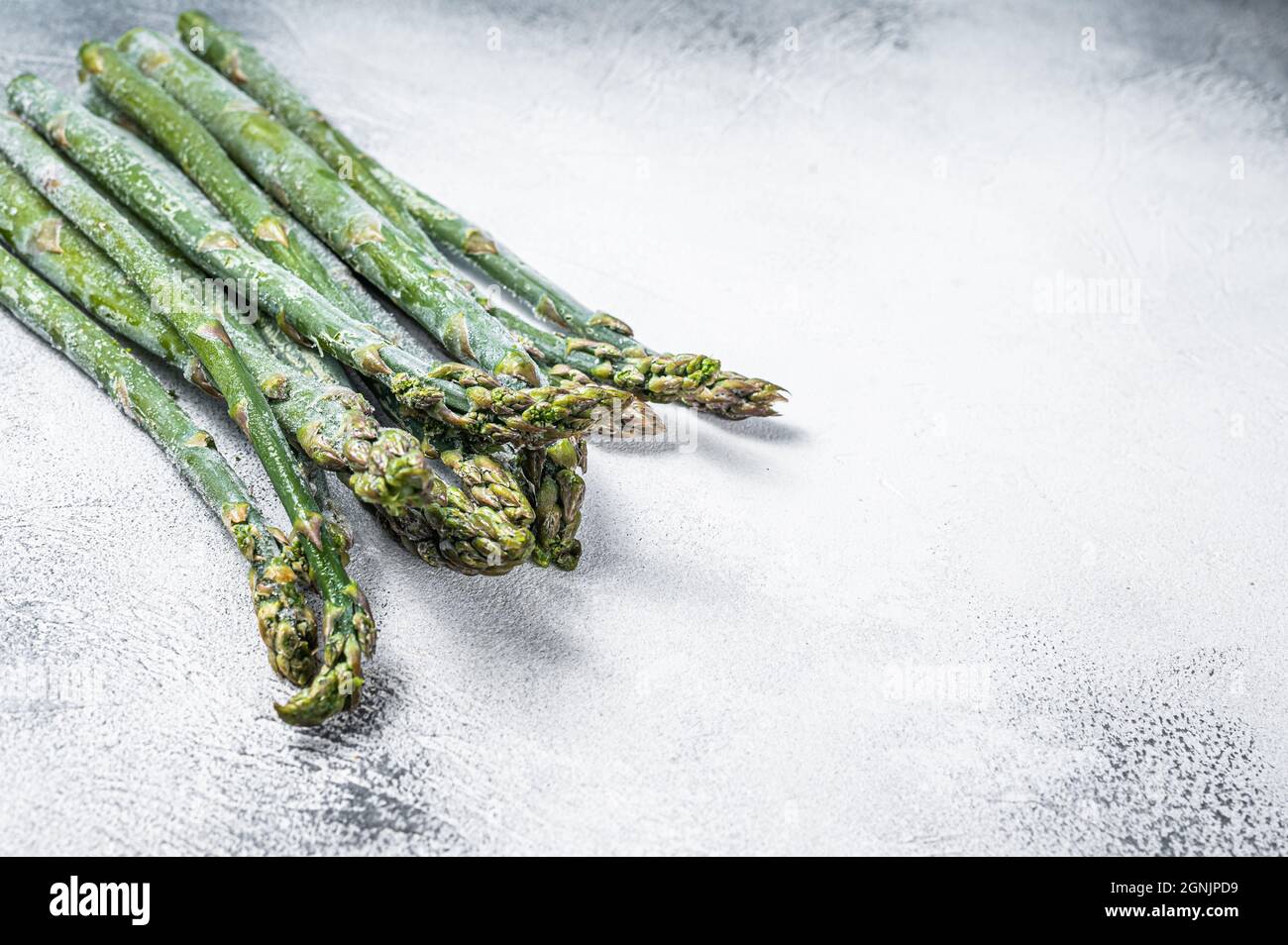 Frozen cold asparagus on a old kitchen table. White background. Top ...
