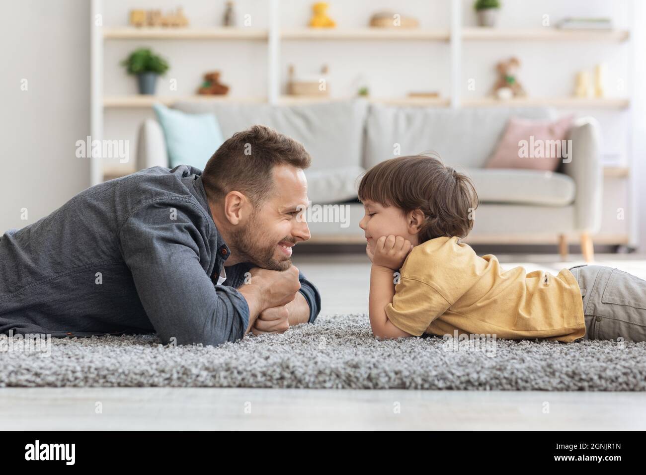 Side view portrait of handsome father and his cute little son looking ...