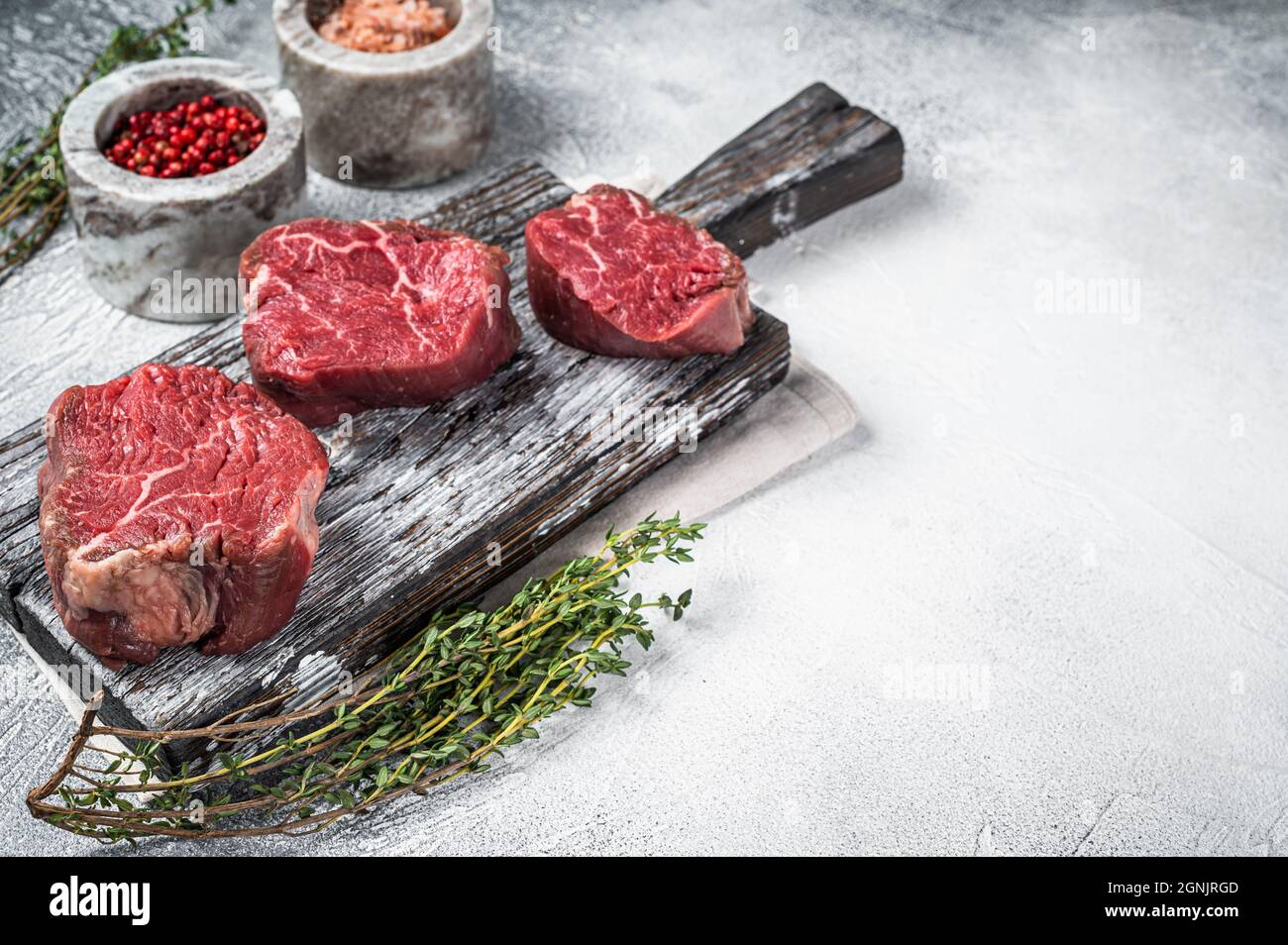 Fillet mignon beef raw steaks on a wooden board with salt and pepper ...