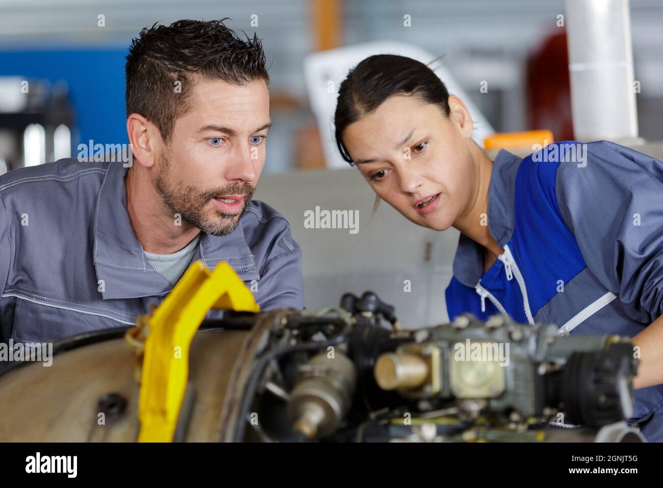 confused male and female mechanic examining car engine Stock Photo - Alamy