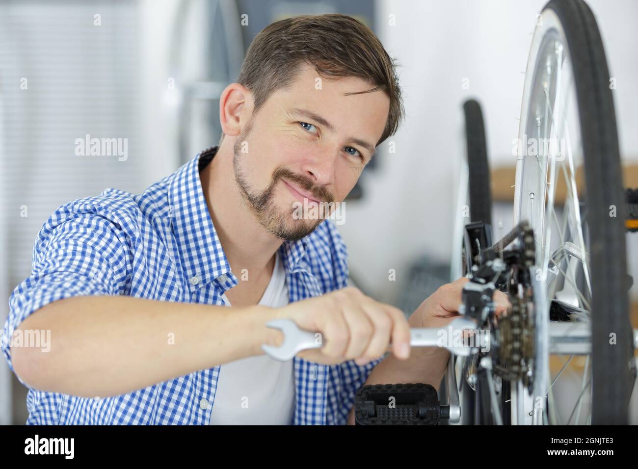 mechanic working on bicycle with spanner Stock Photo - Alamy