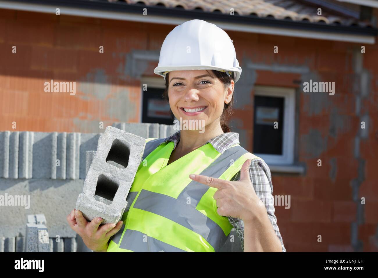 woman builder holding a cement block Stock Photo - Alamy