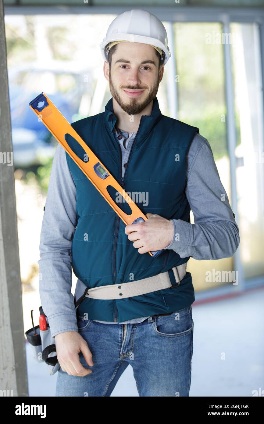 building worker posing for a photo with a level Stock Photo - Alamy