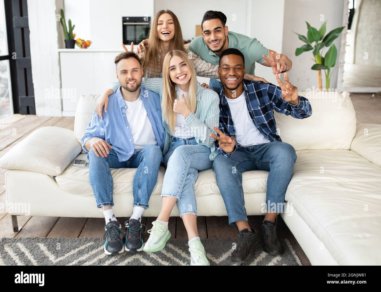 Emotional international group of friends sitting on couch at home ...