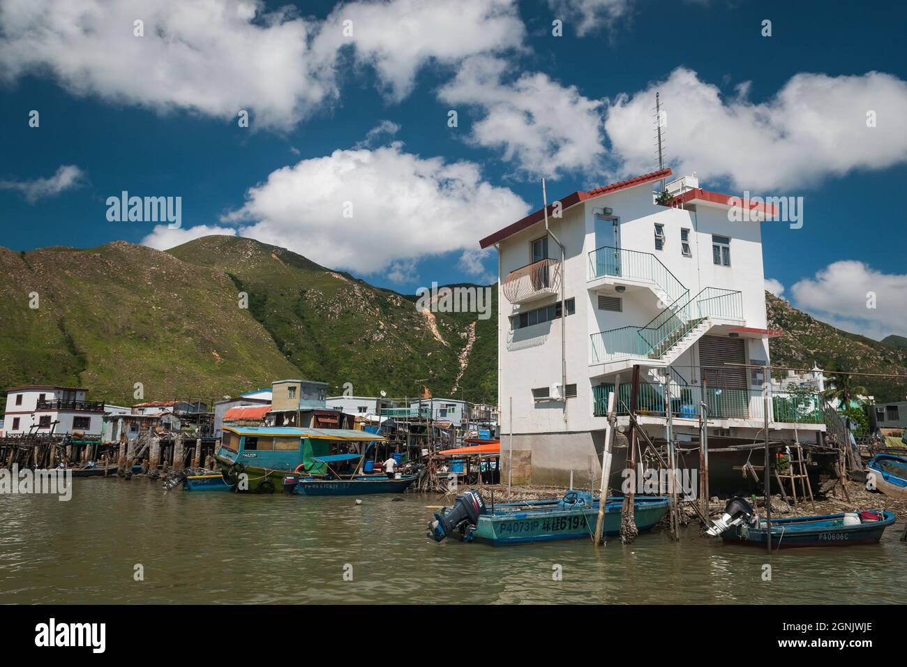A modern village house on a concrete base among stilt houses ('pang uk ...