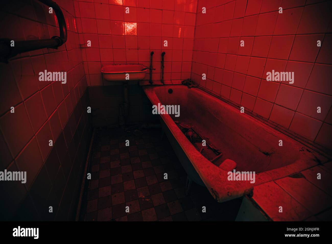 Creepy bath room in abandoned hospital. Red illuminated, horror concept ...