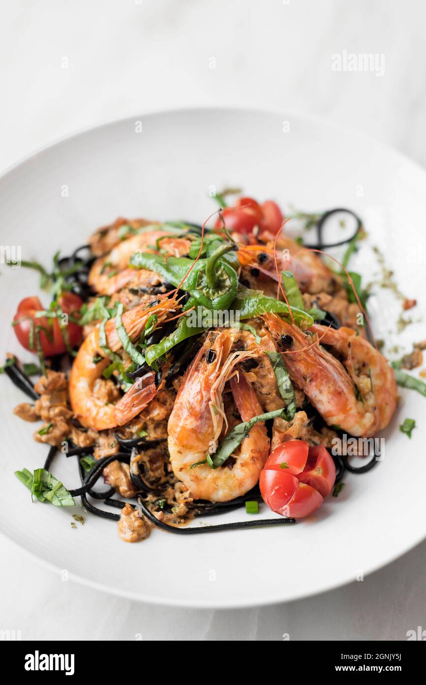 black squid ink spaghetti pasta with shrimp and mixed vegetables in ...