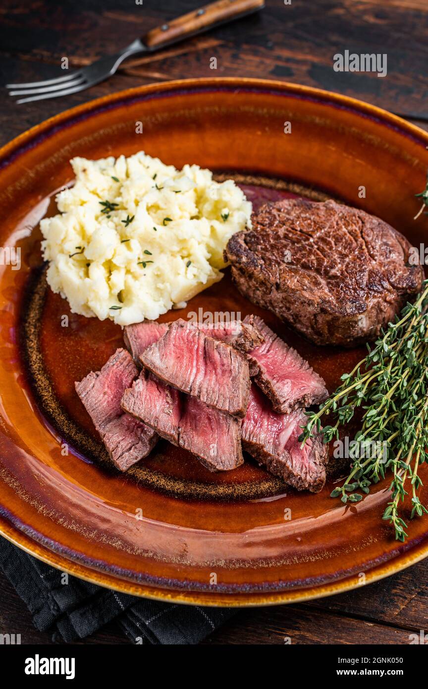 Sliced fillet mignon or tenderloin beef steak on a rustic plate with ...