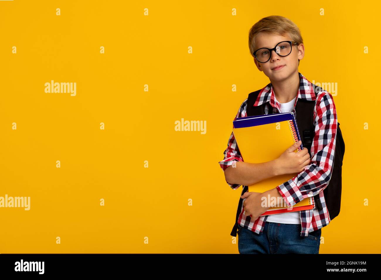 Calm clever caucasian teenage boy pupil in glasses with books and ...