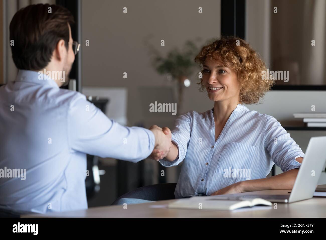 Happy confident young businesswoman shaking hands with client Stock ...