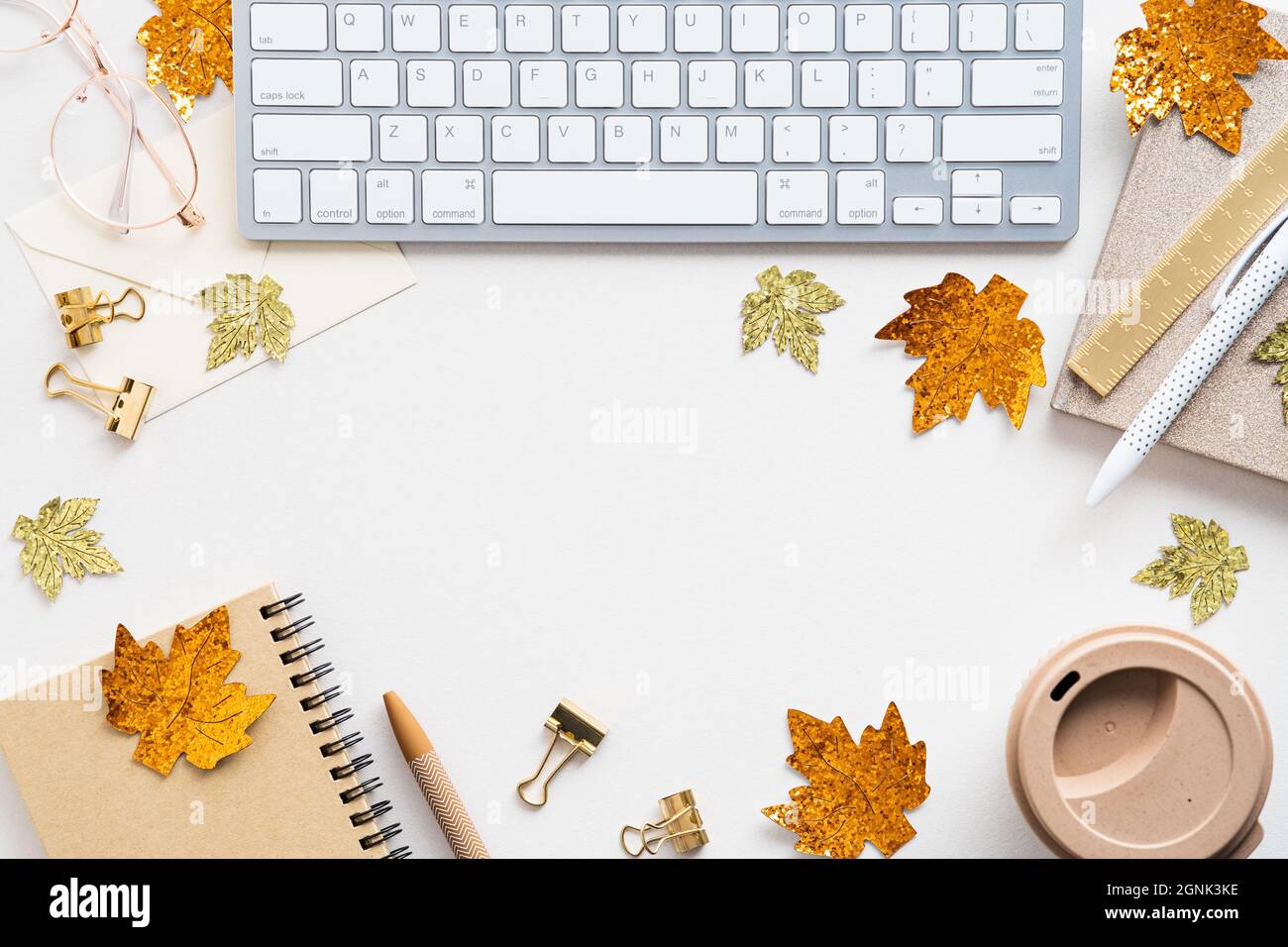 Autumn desk with keyboard, coffee cup, notebook, maple leaves decor on ...