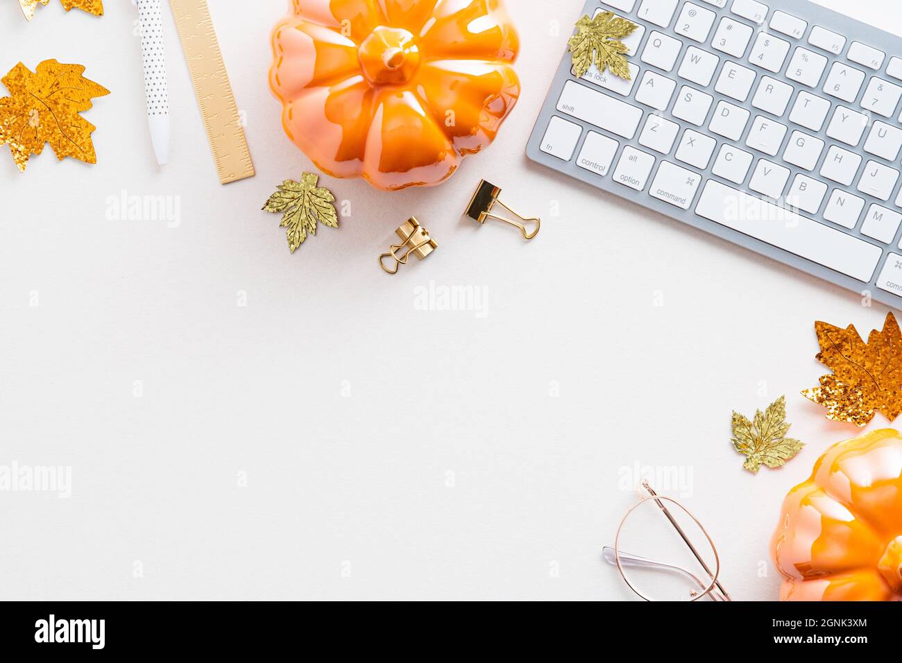 Autumn desk table with keyboard, pumpkins, glasses on white background ...
