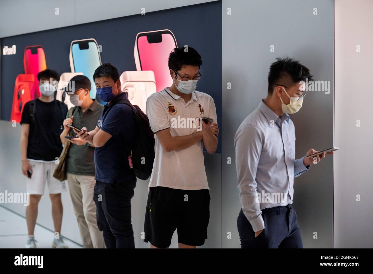Shoppers queue in line at an Apple store during the launch day of the ...