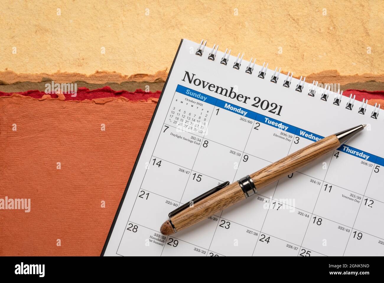 November 2021 - spiral desktop calendar against abstract paper ...