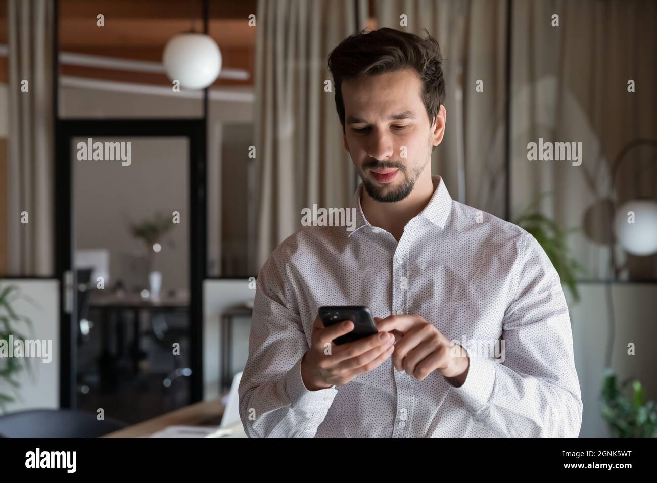Serious millennial businessman texting message on smartphone Stock ...