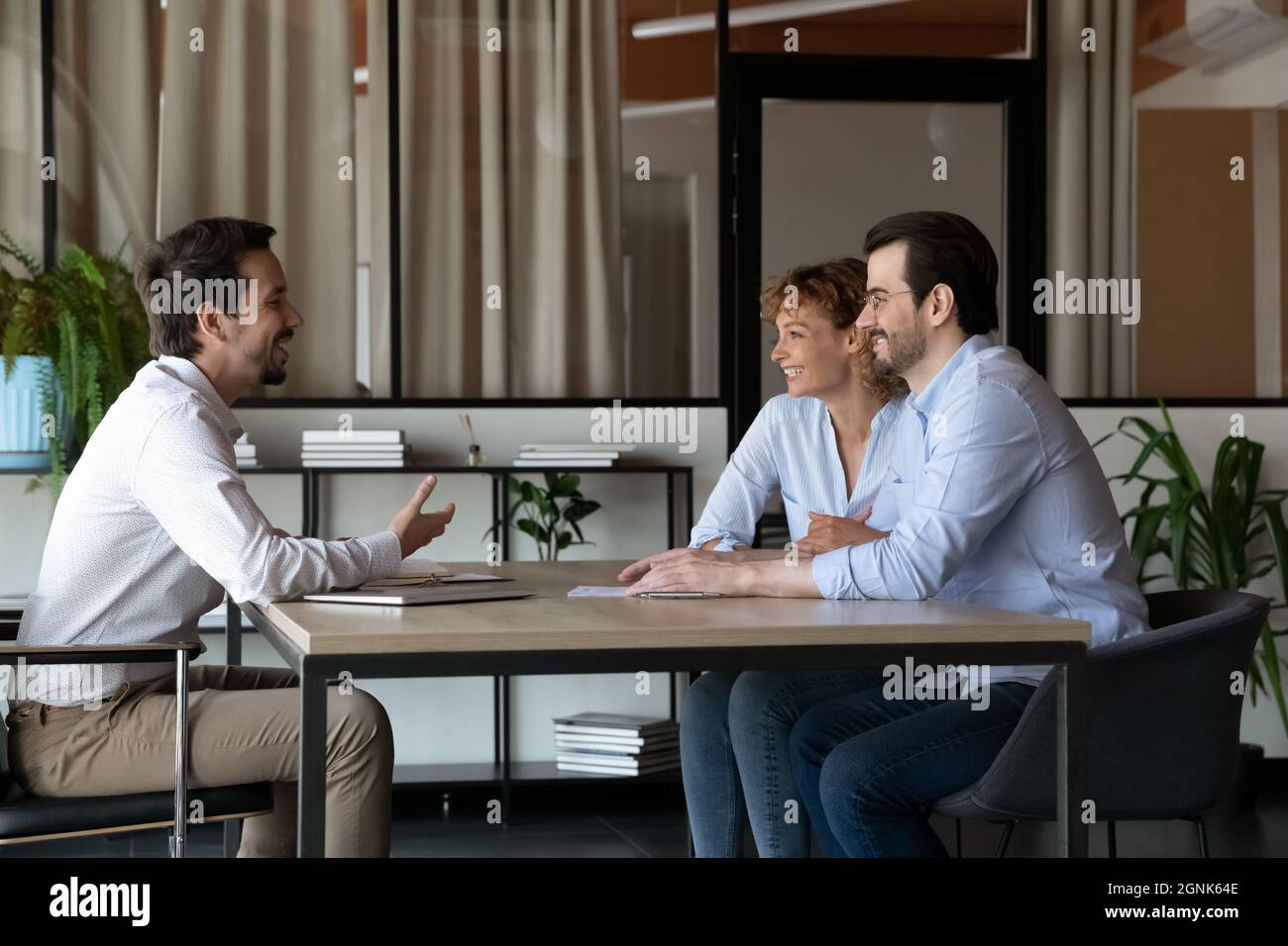 Happy family couple of clients meeting with real estate agent Stock ...